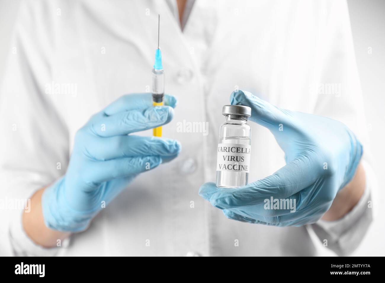 Doctor holding chickenpox vaccine and syringe, closeup. Varicella virus ...