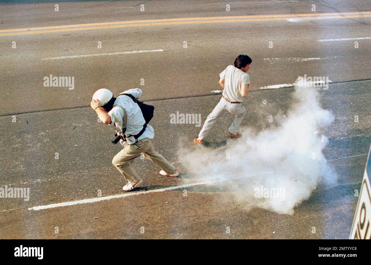 A photographer and an anti-government demonstrator run in opposite ...