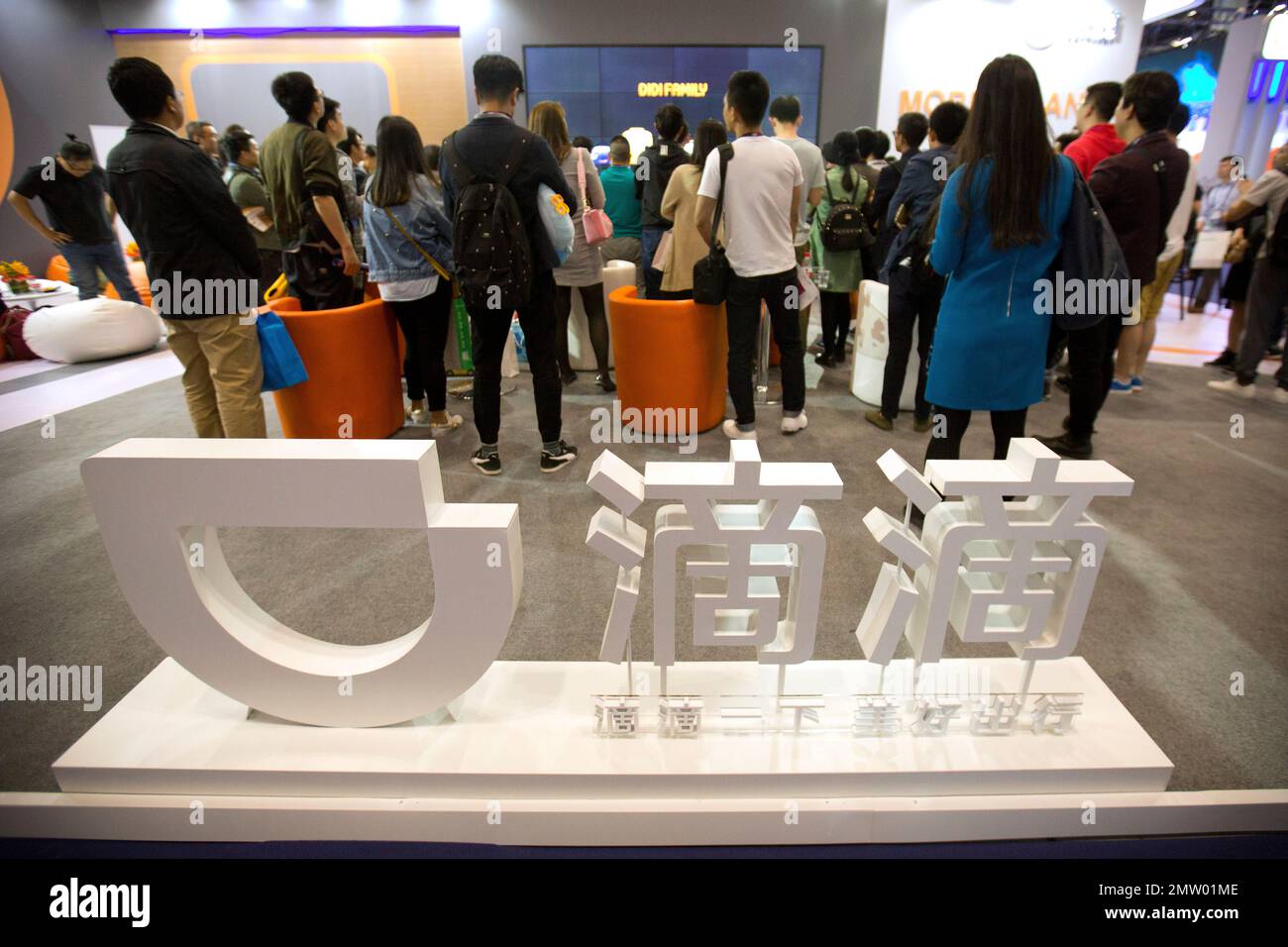 Visitors look at a display booth for Chinese ride-hailing service Didi ...