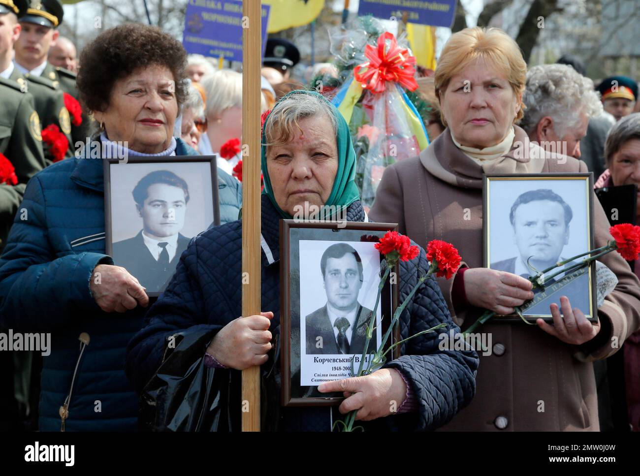 Widows of Chernobyl victims hold portraits of their husbands who died ...