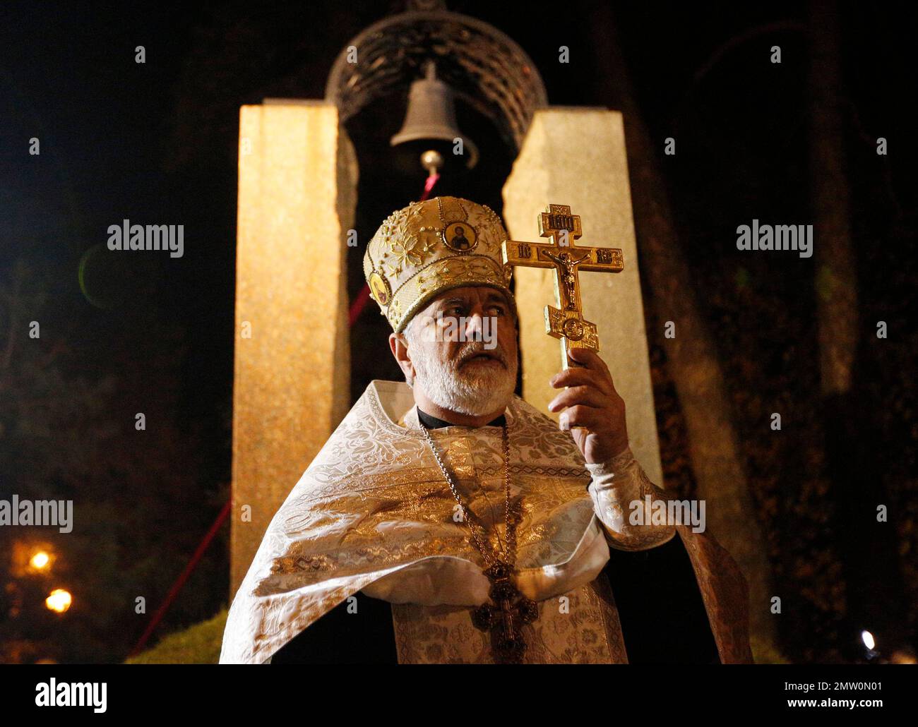 An Orthodox priest attends a memorial service for the victims of the ...