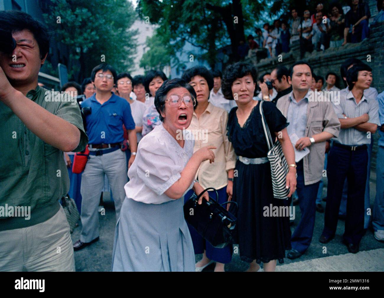 A woman shouts as a prison bus carrying five policemen, including three ...