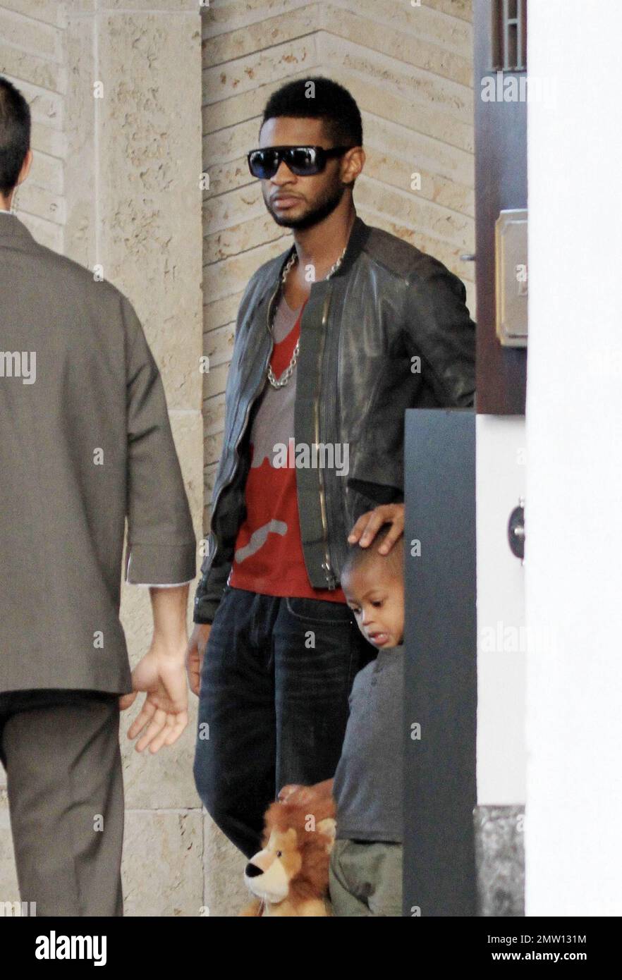 Rapper Usher and his children with the help of bodyguards and staff ...