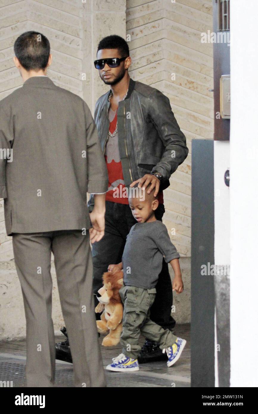 Rapper Usher and his children with the help of bodyguards and staff ...