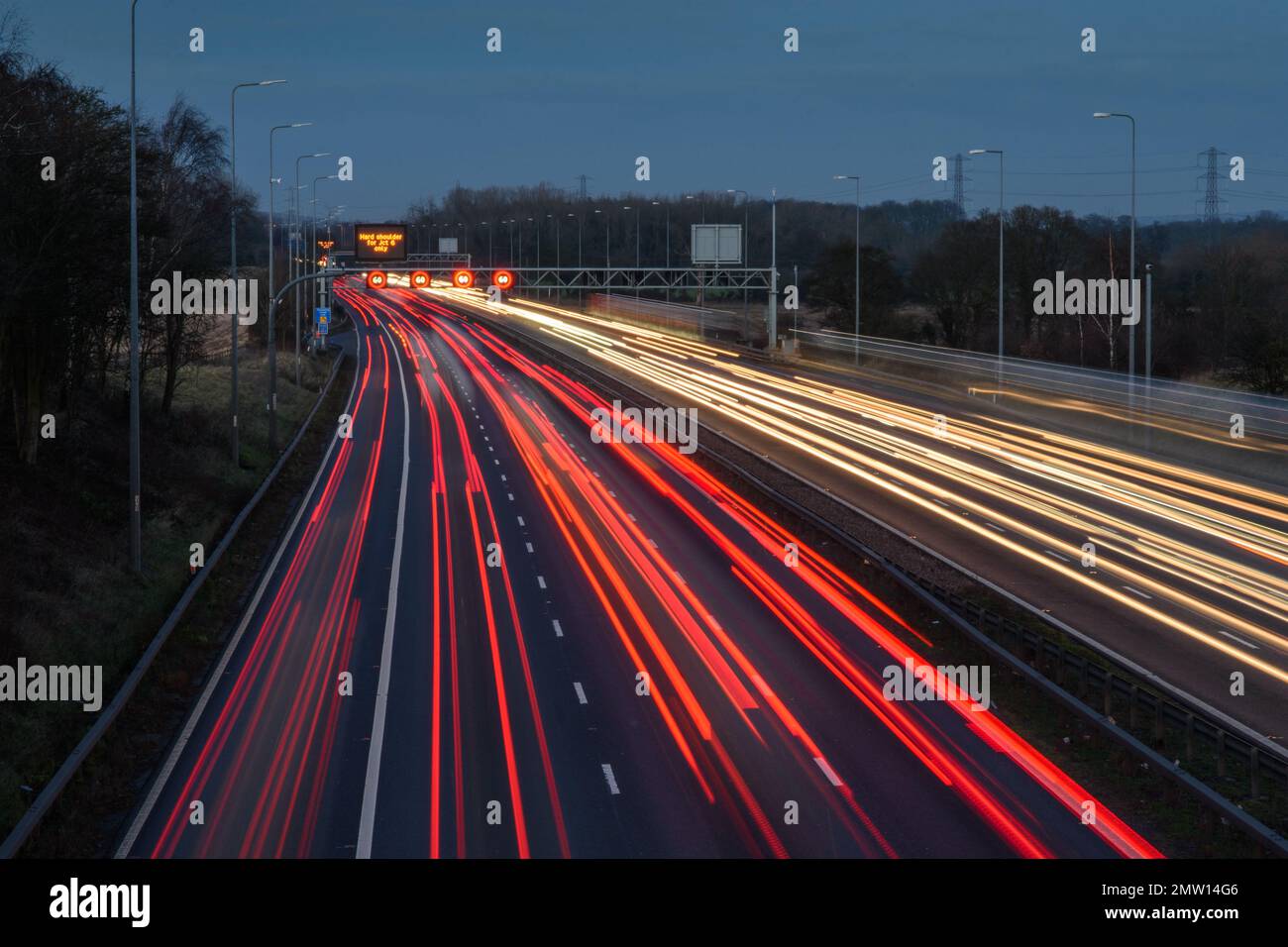 Speeding traffic on M42 motorway during evening rush hour leaves light ...