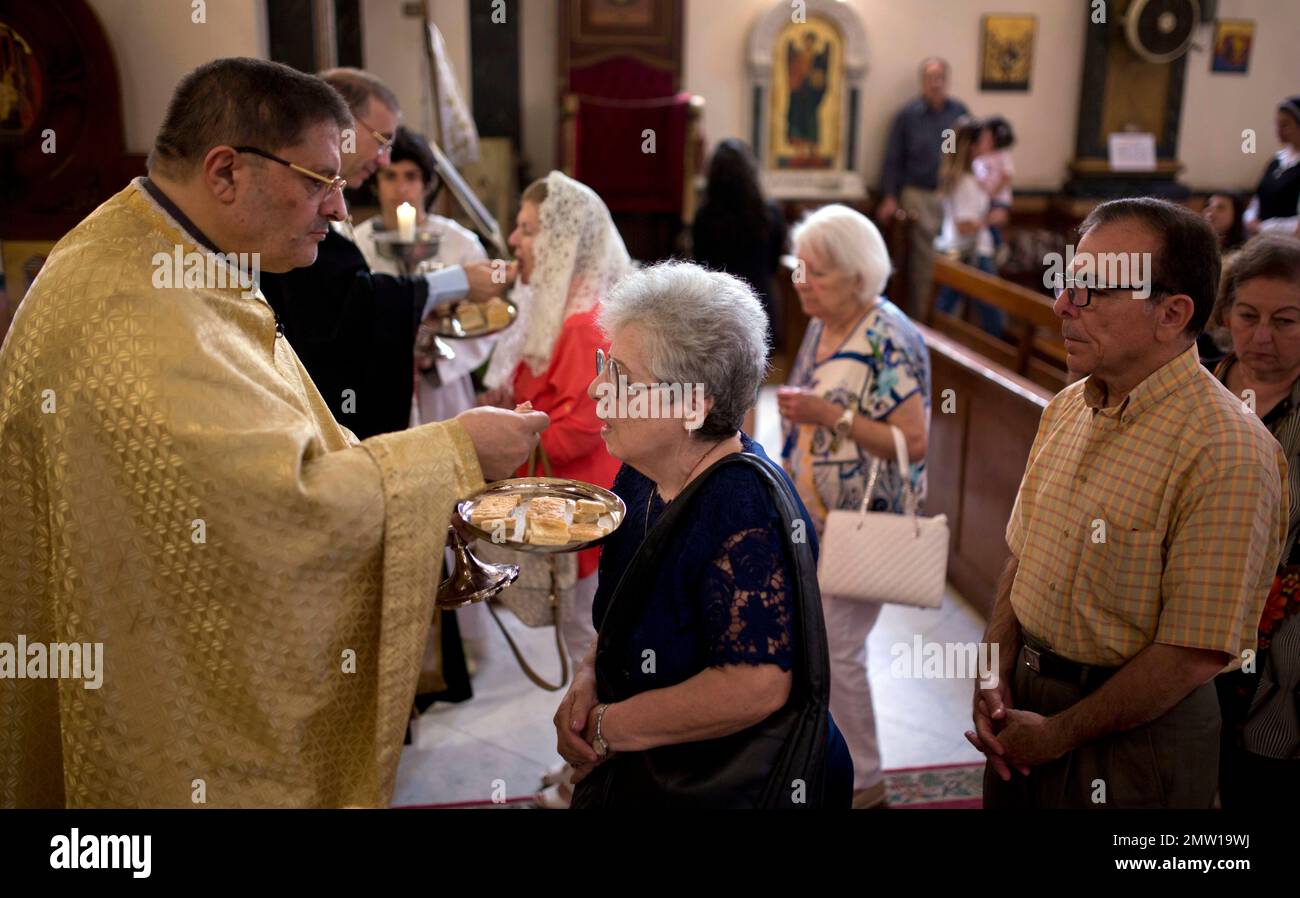Worshippers receive communion during a service at Saint Cyrill Greek ...