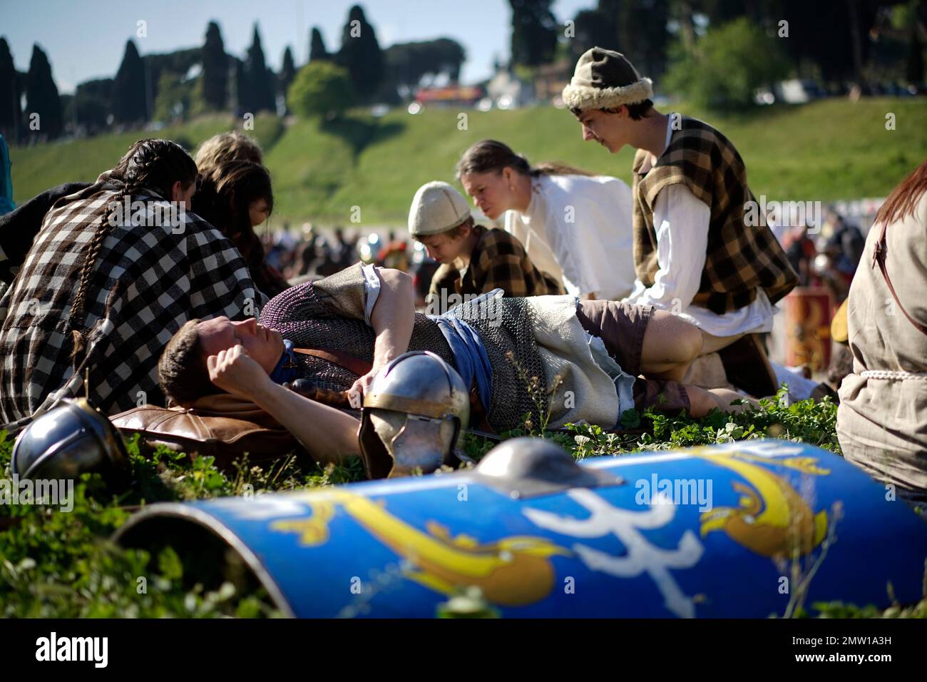 Performers dressed in traditional ancient Roman dresses relax before ...