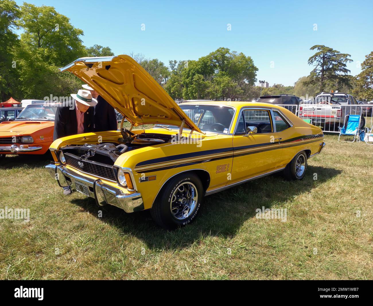 Judges examine an old yellow sport 1970s Chevrolet Chevy 250 SS Series ...