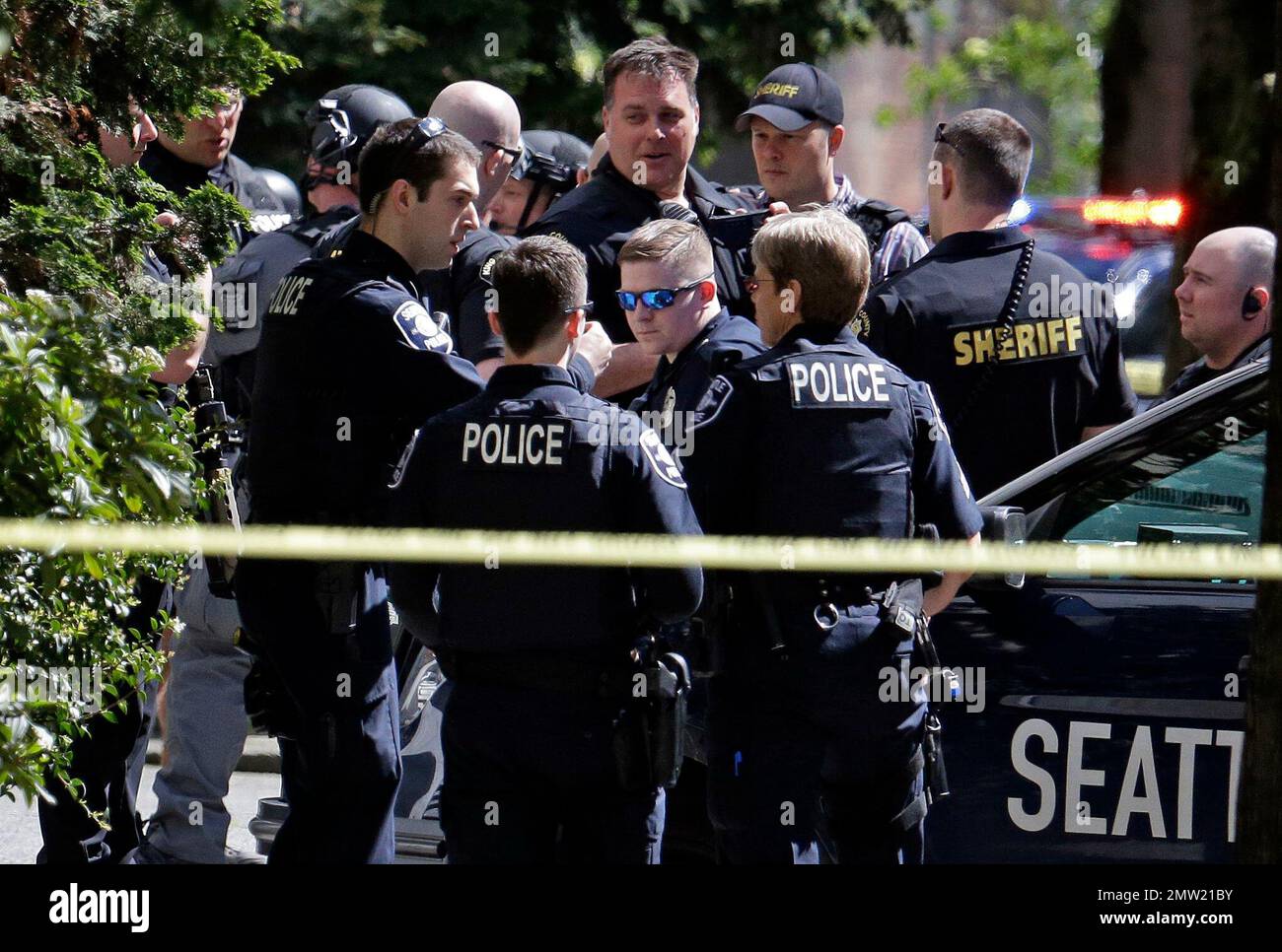 Police officers gather together near the scene of where two police ...