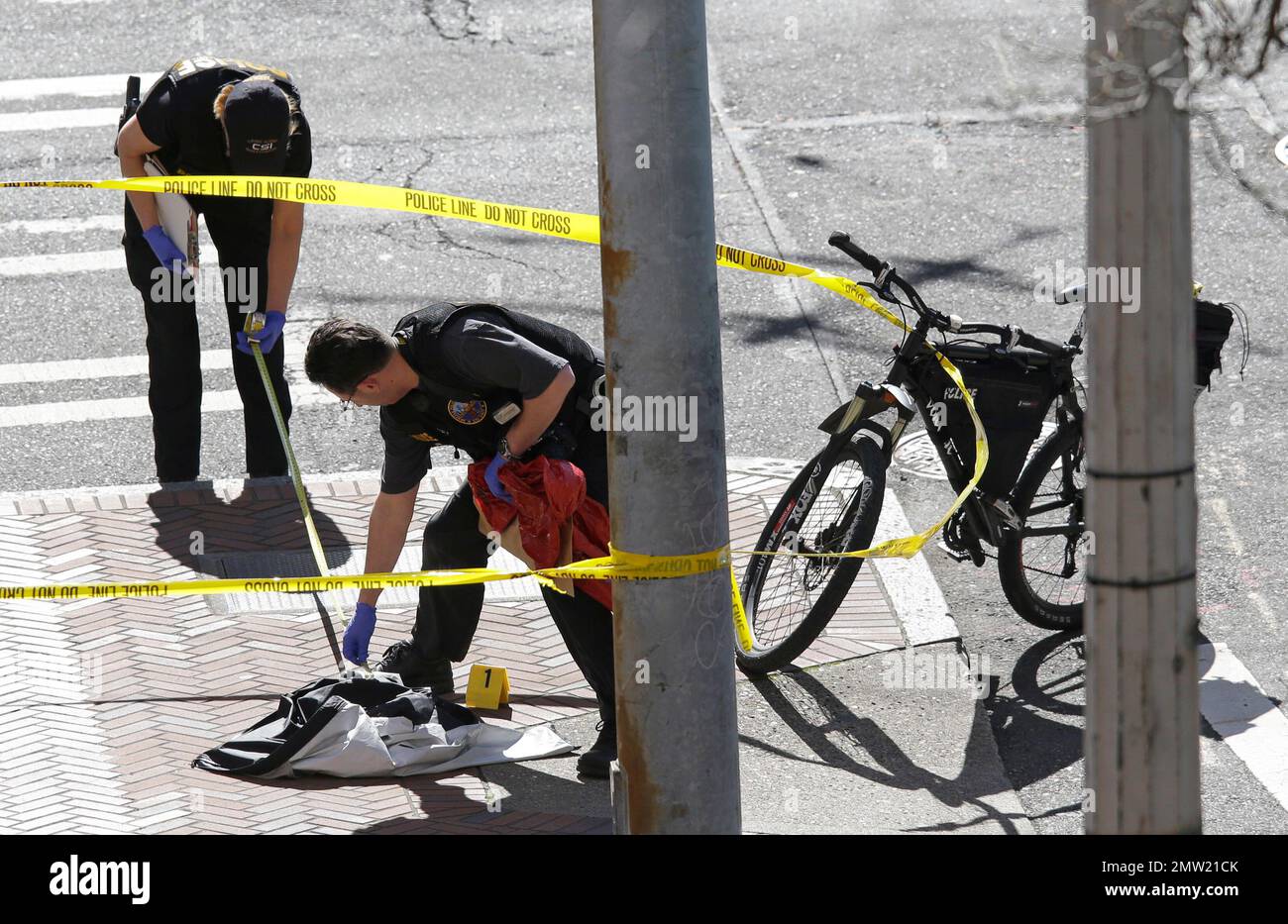 Seattle Police crime scene investigators take measurements near the ...