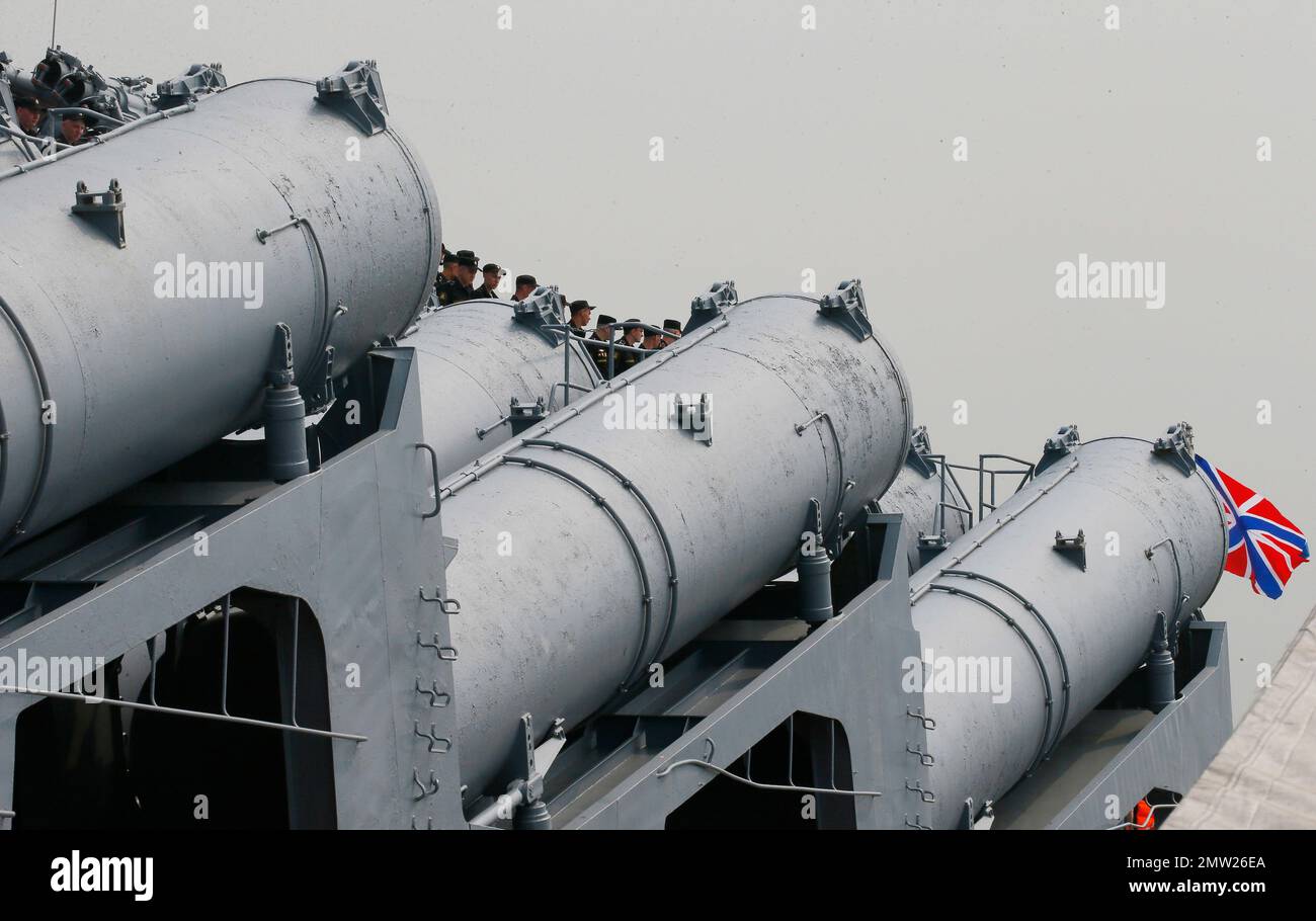 Russian sailors stand at attention behind missiles on board the guided ...