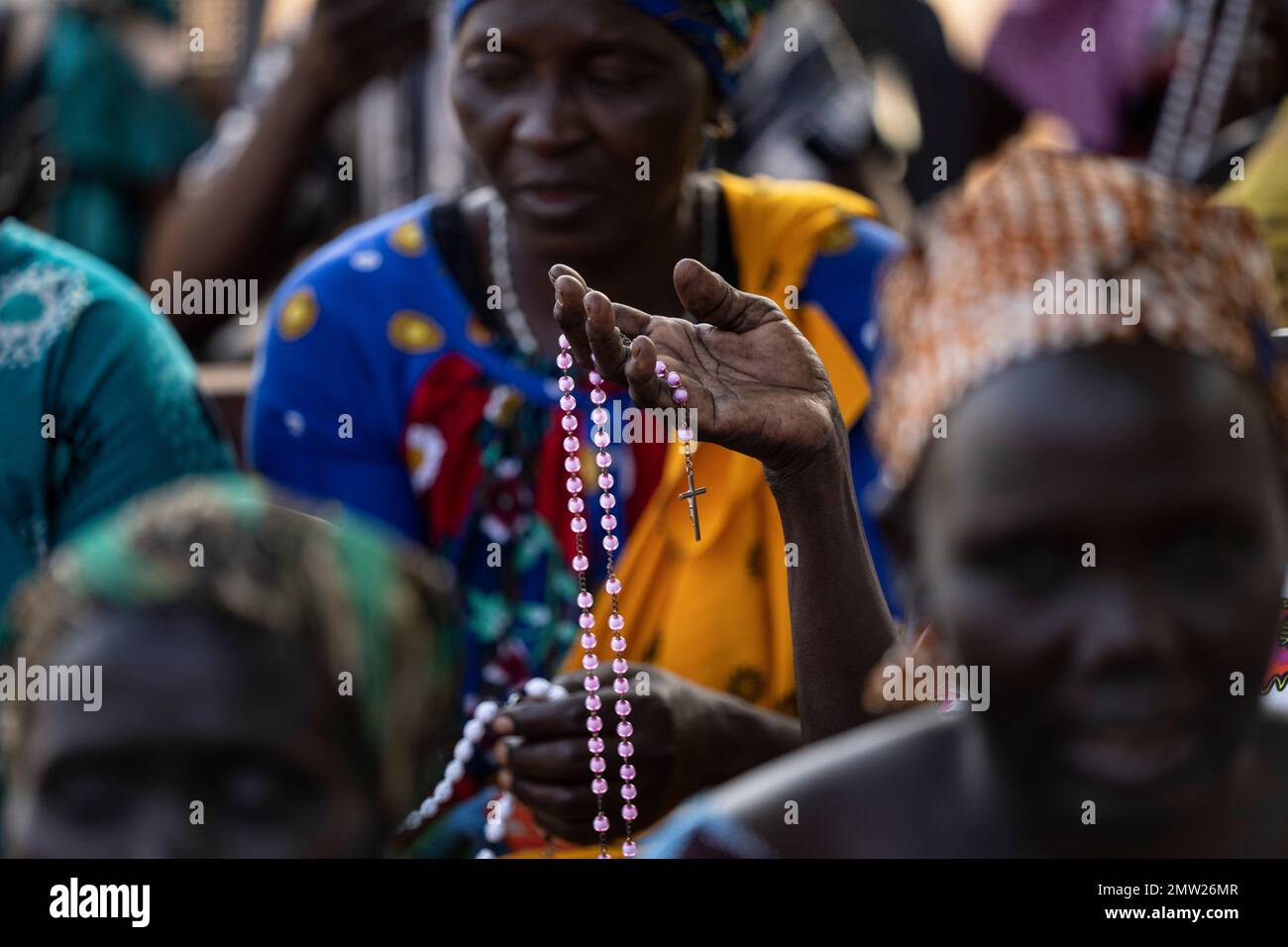 Women hold rosary beads as they pray and sing in the courtyard of the ...