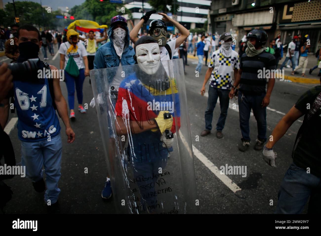 An anti-government protester wearing a mask carries a shield during ...