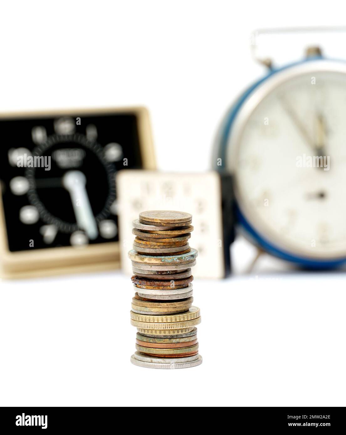 vintage rusty coins in front of alarm clock. time is money concept ...