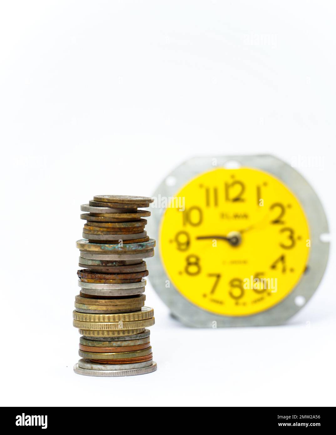 vintage rusty coins in front of alarm clock. time is money concept ...