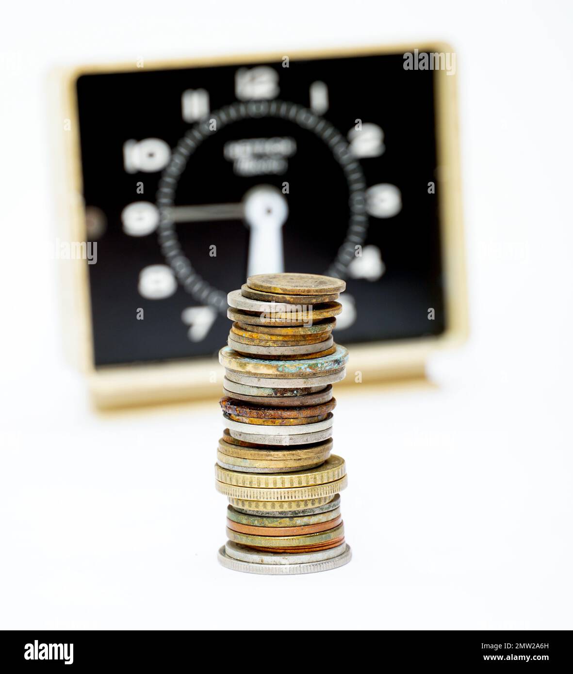 vintage rusty coins in front of alarm clock. time is money concept ...
