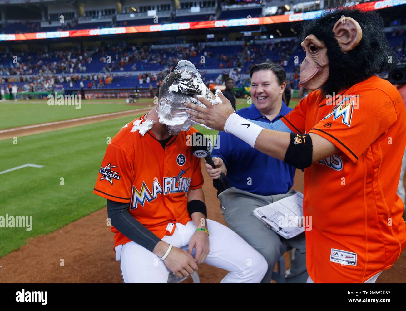 Wearing a monkey mask, Miami Marlins second baseman Miguel Rojas, right ...