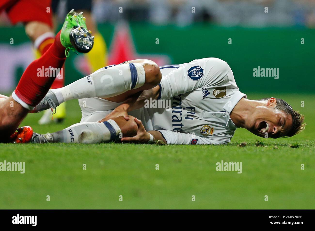 Real Madrid's Cristiano Ronaldo holds his left knee after a tackle ...