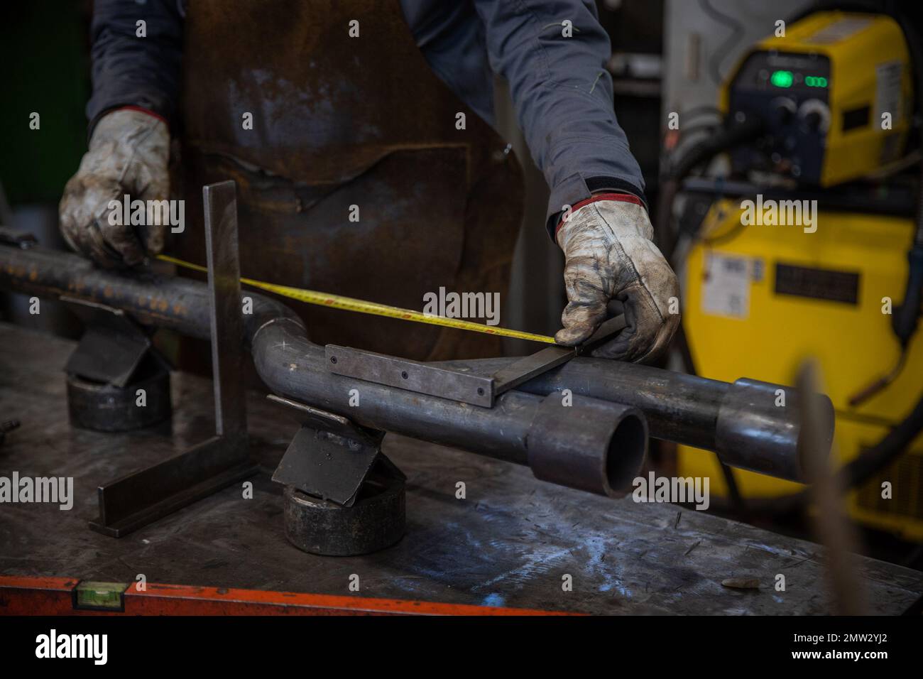 Close-up of a worker's hands measuring a pipe in a factory Stock Photo ...