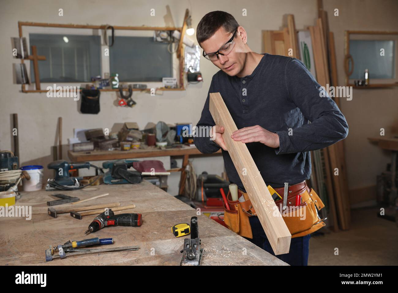 Professional carpenter working with wooden plank in workshop Stock ...
