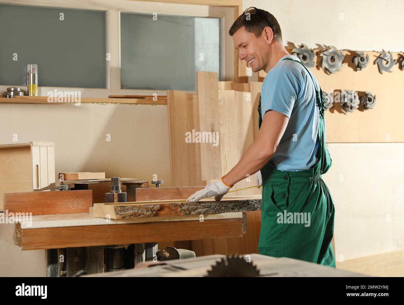 Professional carpenter measuring wooden board in workshop Stock Photo ...