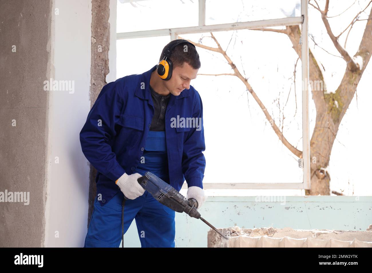 Worker using rotary drill hammer for window installation indoors Stock ...