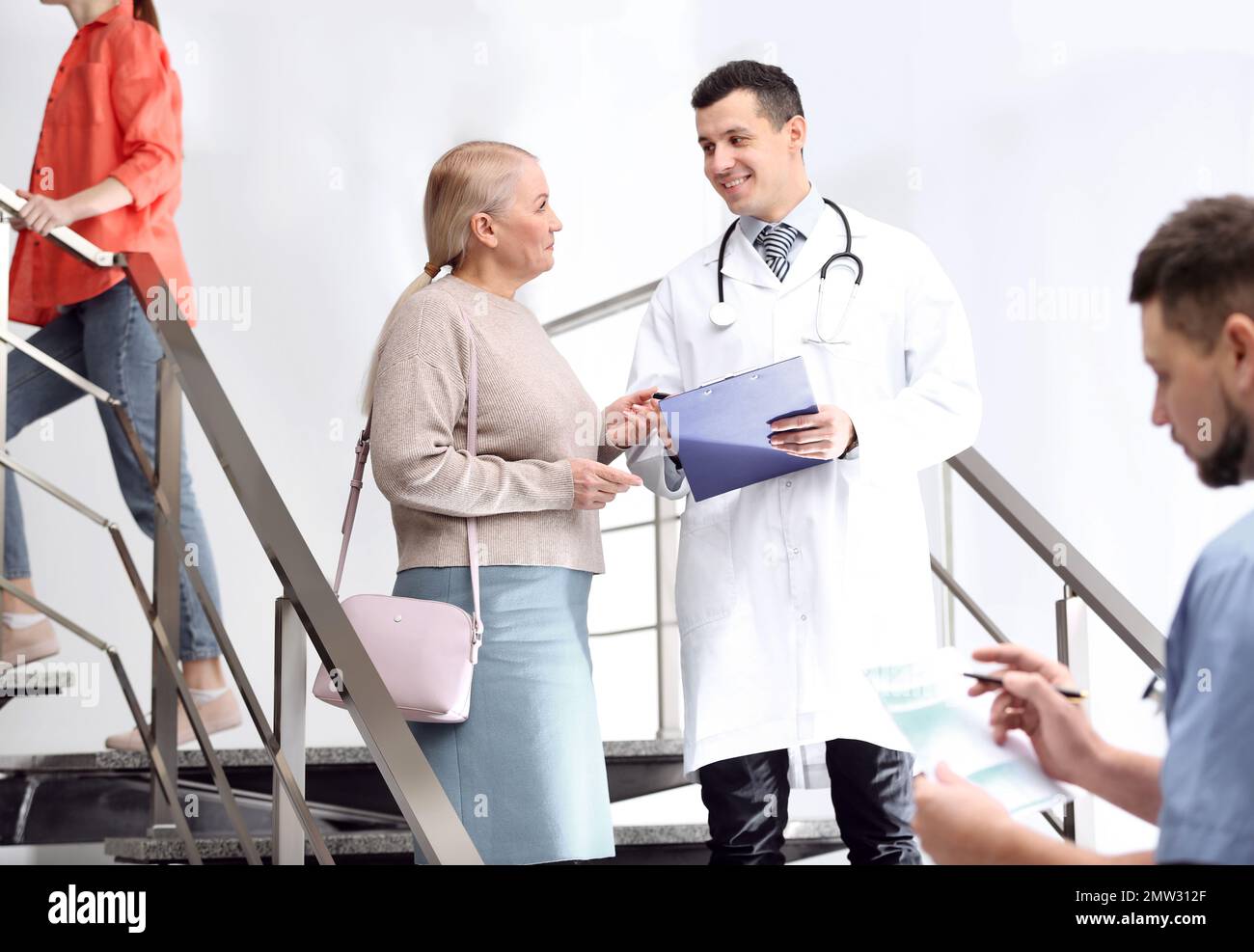 Doctor and patient discussing diagnosis on stairs in hospital Stock ...