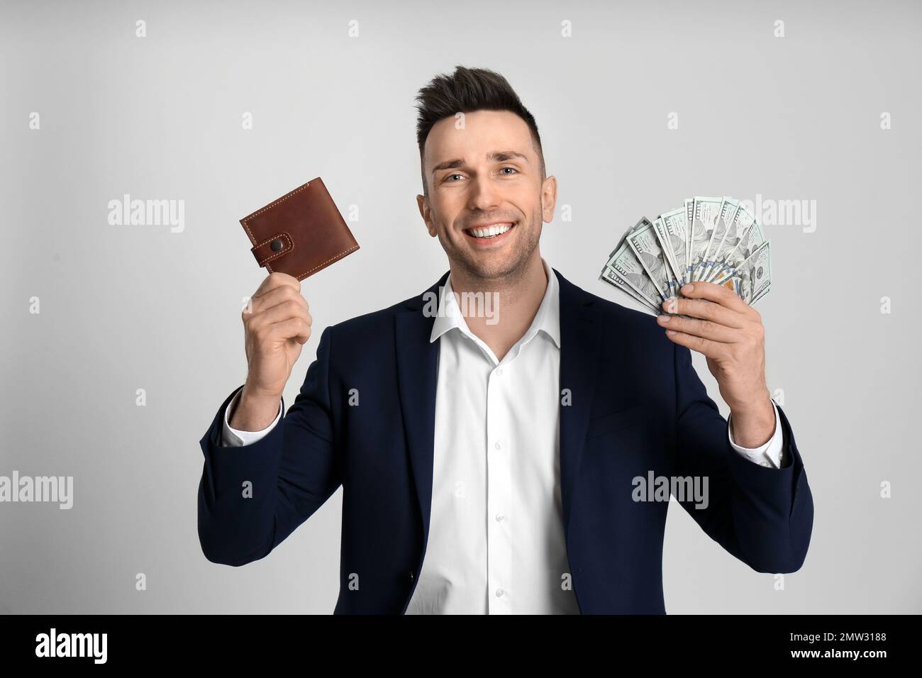 Happy man with cash money and wallet on light grey background Stock ...