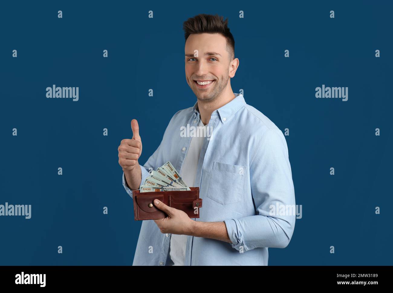 Happy man with cash money and wallet on blue background Stock Photo - Alamy