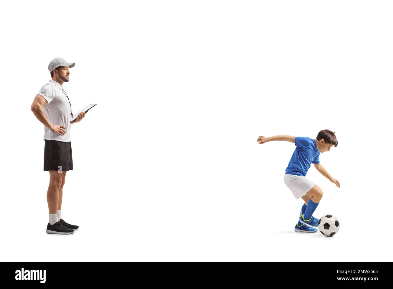 Full length profile shot of a football coach watching a boy training ...