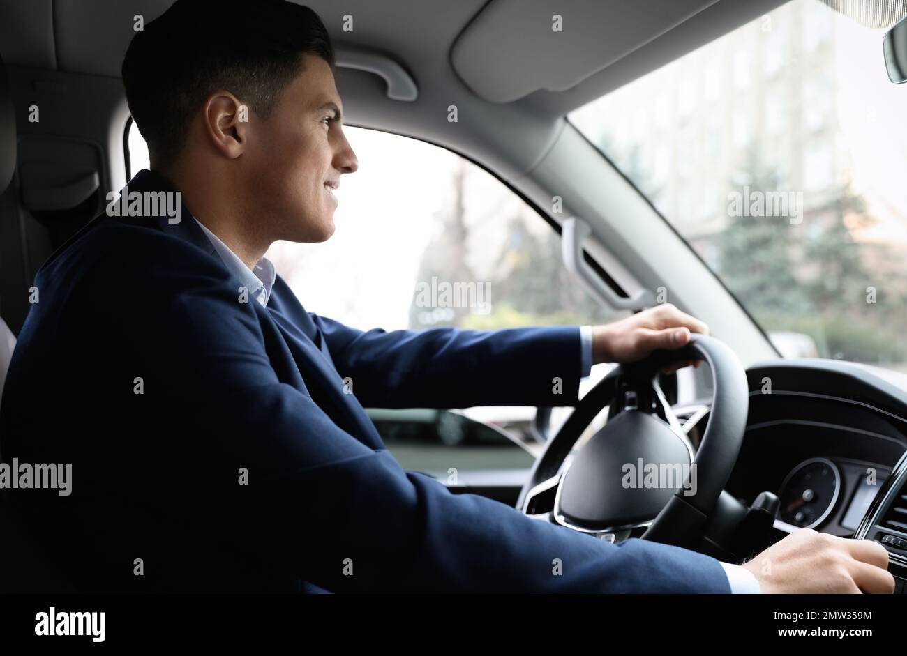 Handsome man in suit driving his modern car Stock Photo - Alamy