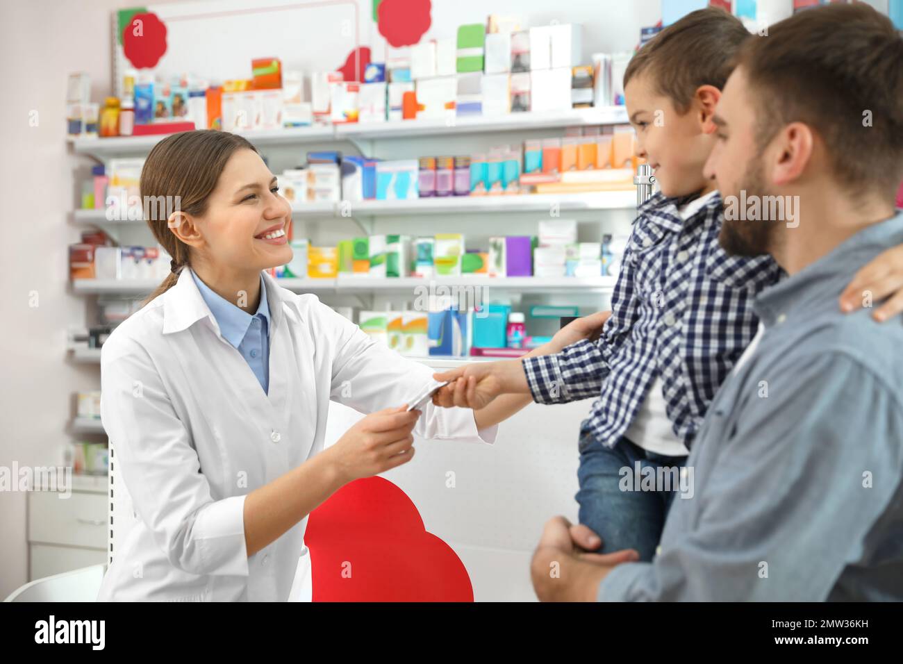Professional pharmacist giving pills to customer in modern drugstore ...
