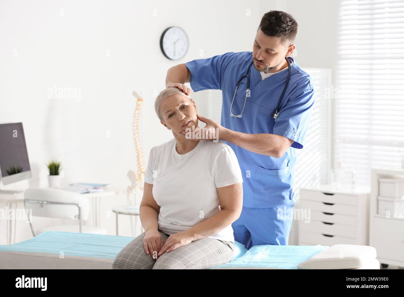 Male orthopedist examining patient with injured neck in clinic Stock ...