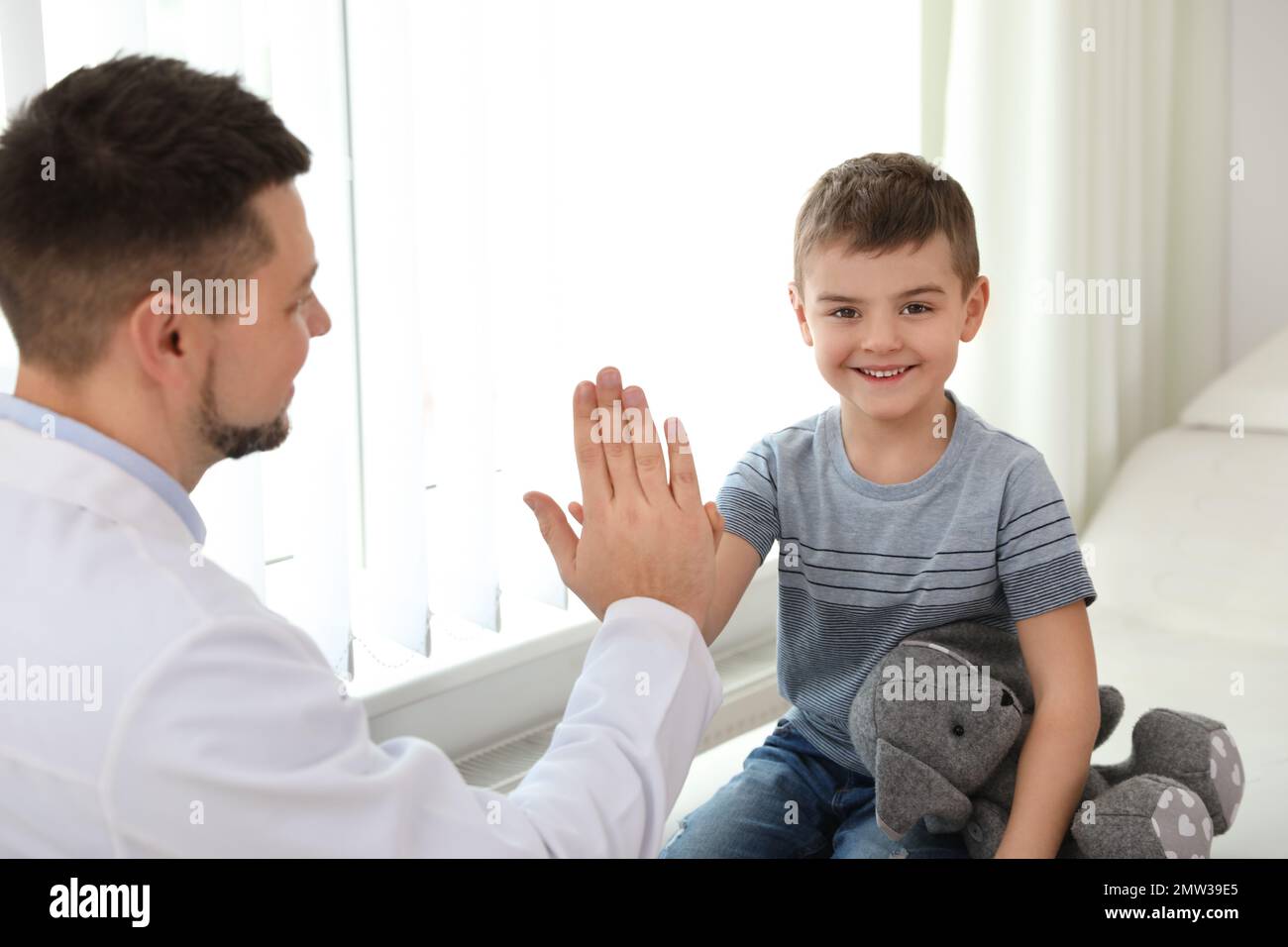 Children's doctor working with little patient in clinic Stock Photo - Alamy