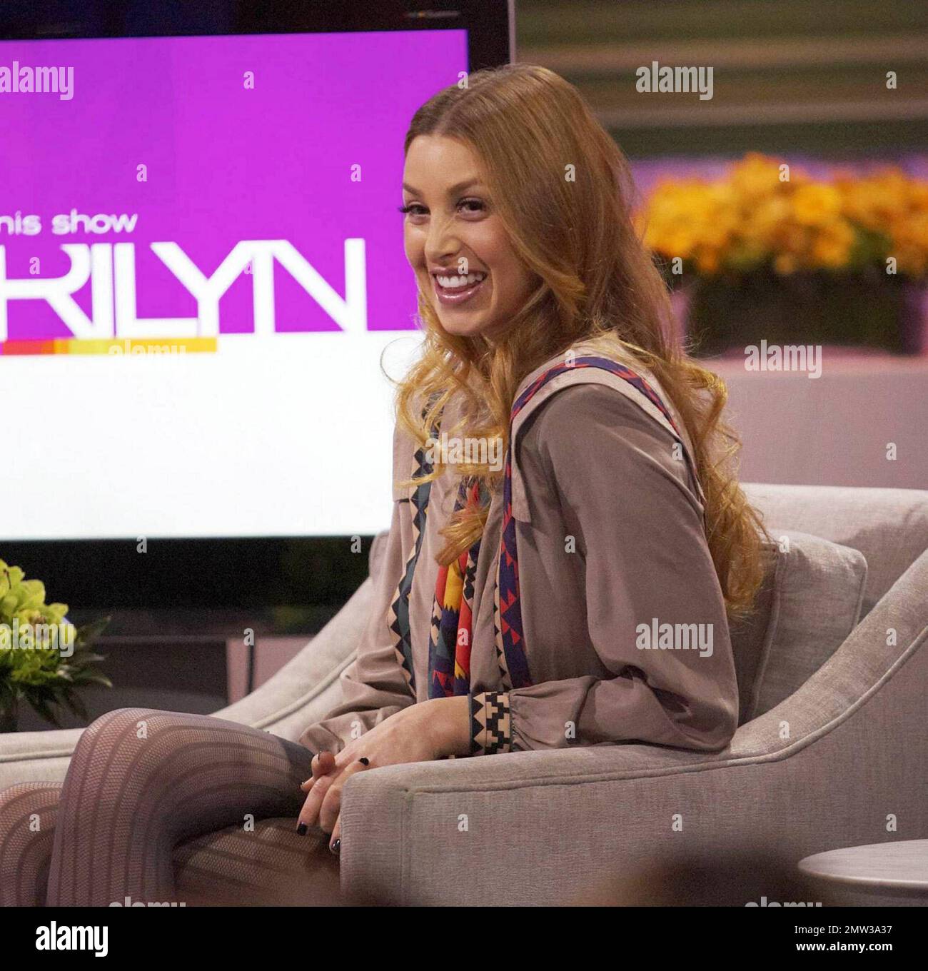 In a patterned scarf, tan blouse and mini skirt reality TV star Whitney ...