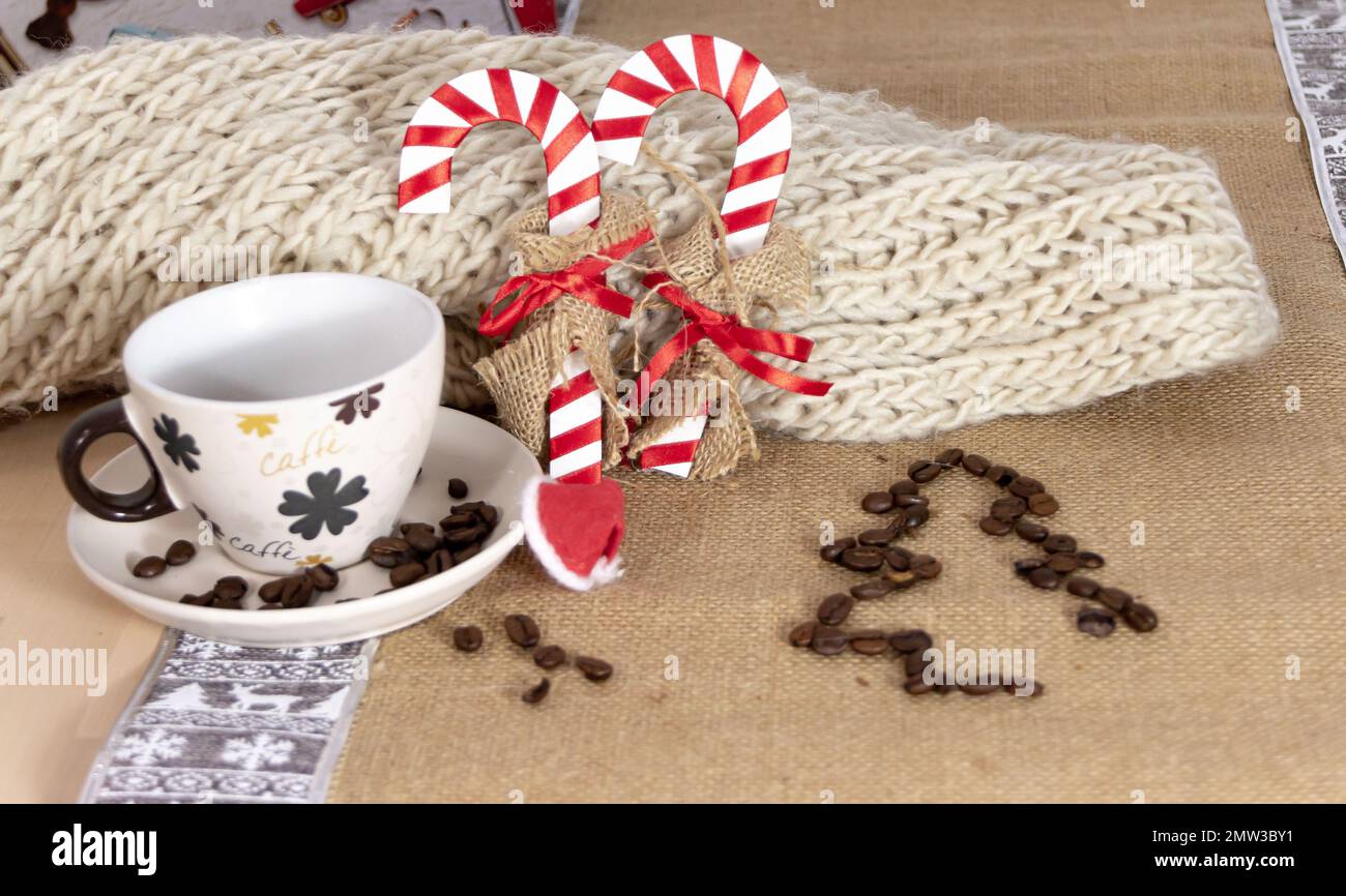 A Christmas table scene with an empty cup of coffee, two decorative ...