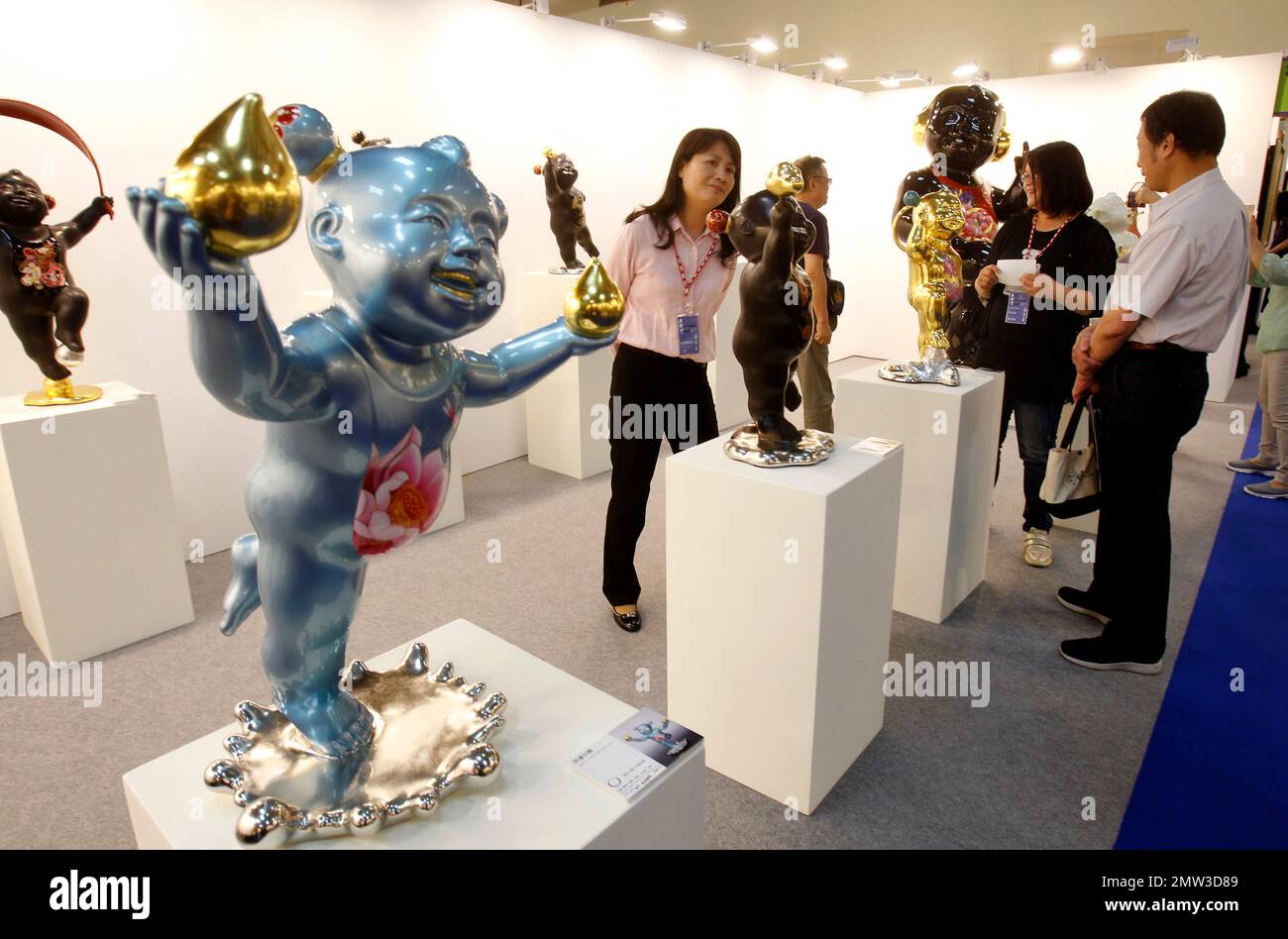 Visitors look at Taiwanese artist Yu Ren's works at the Art Revolution ...