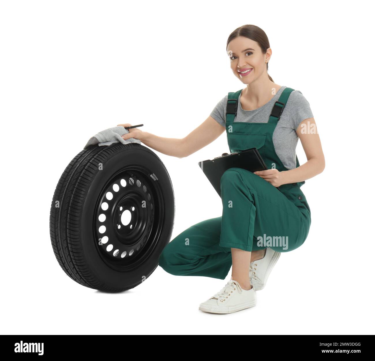 Professional auto mechanic with wheel and clipboard on white background ...