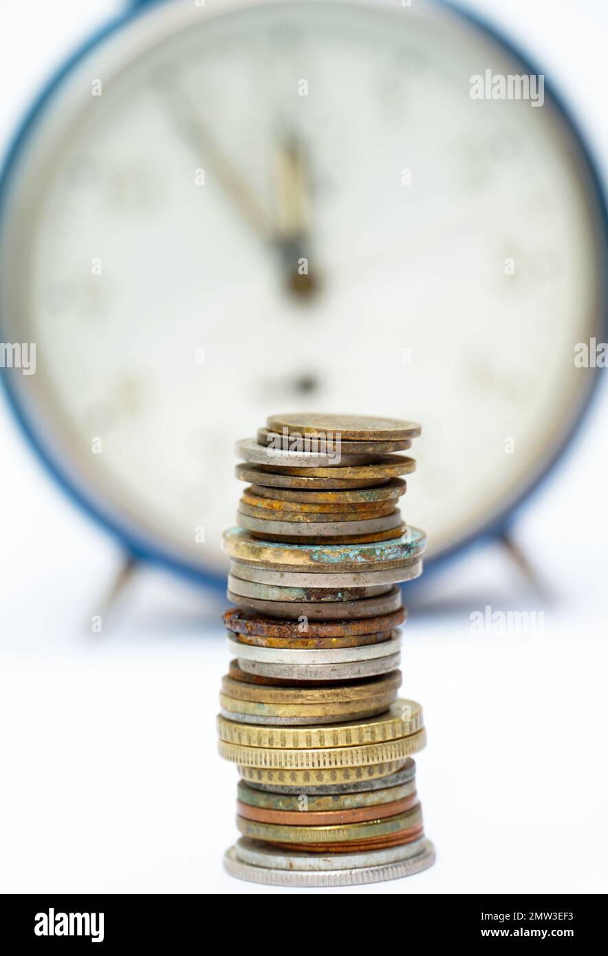 vintage rusty coins in front of alarm clock. time is money concept ...