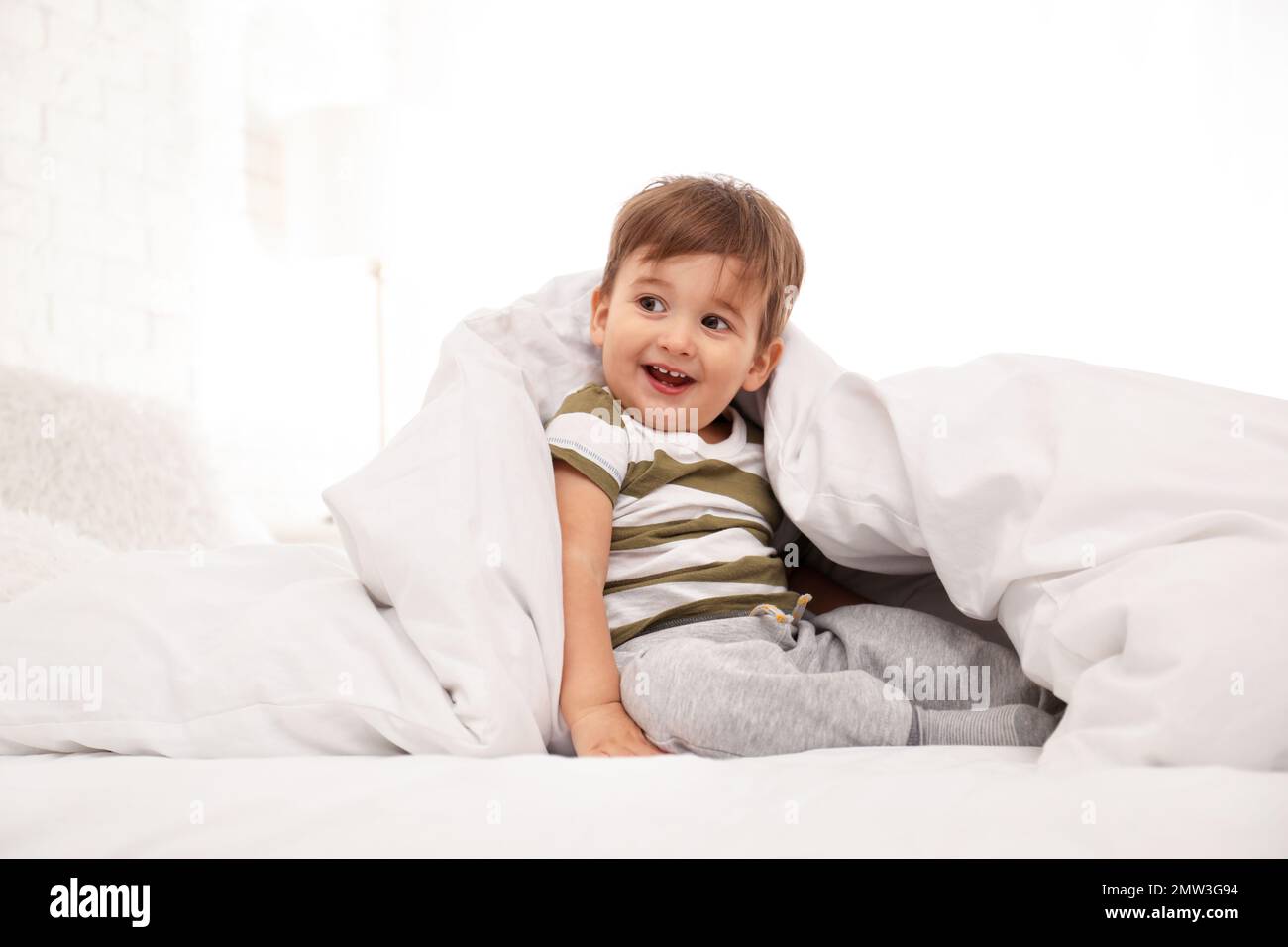 Cute little child playing under blanket in bed Stock Photo - Alamy