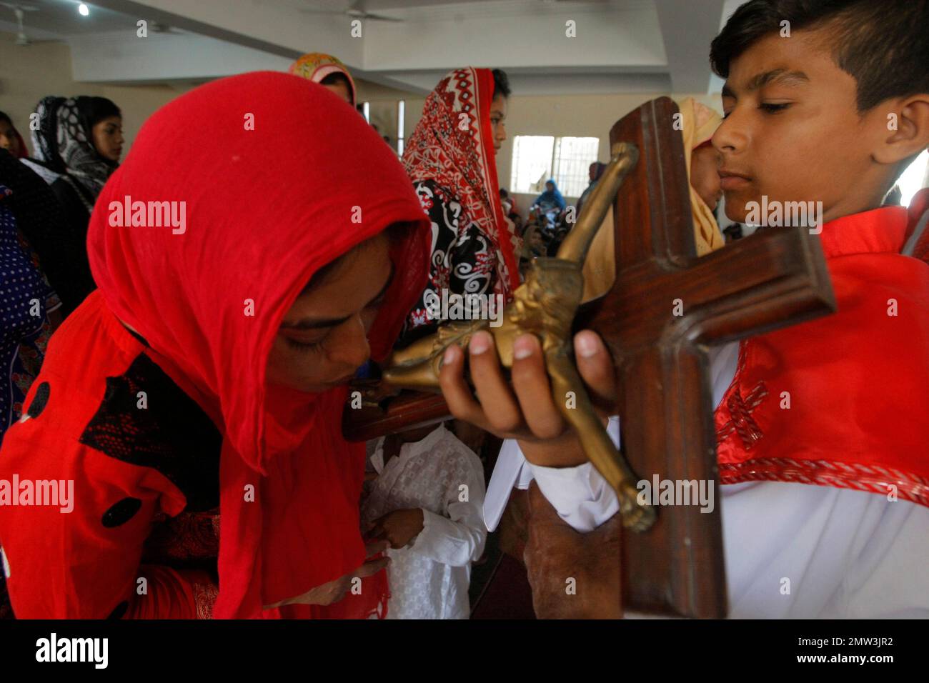A Pakistani Christian kisses a depiction of the crucifixion of Jesus ...