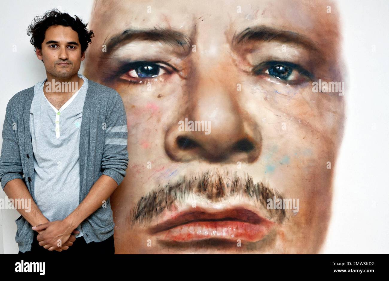 Artist Johan Andersson stands next to his portrait painting of Colonel ...
