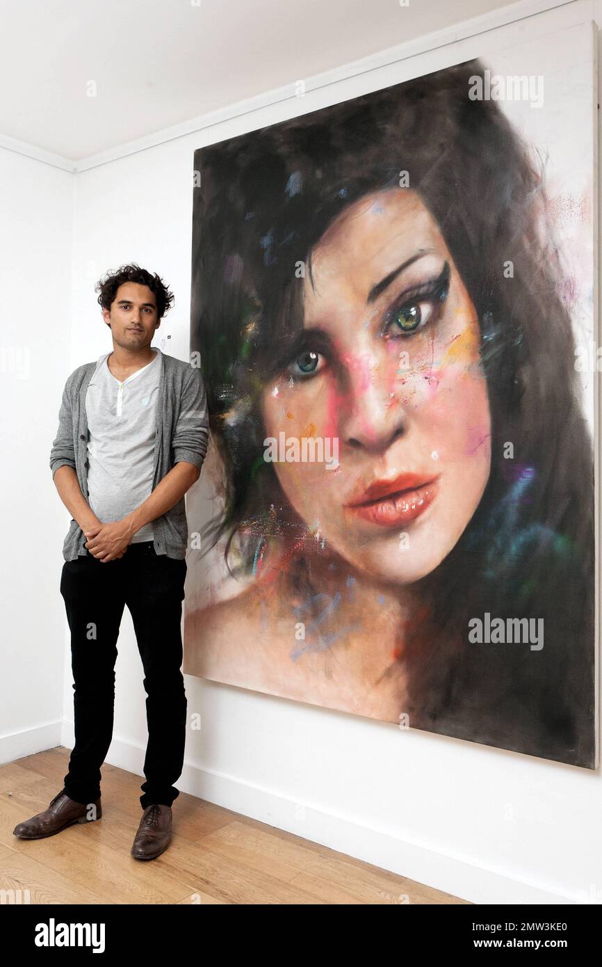 Artist Johan Andersson stands next to his portrait painting of the late ...