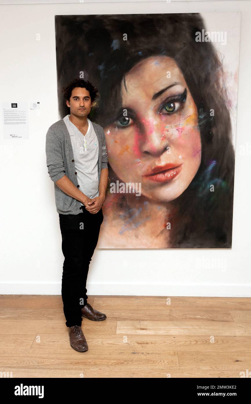 Artist Johan Andersson stands next to his portrait painting of the late ...