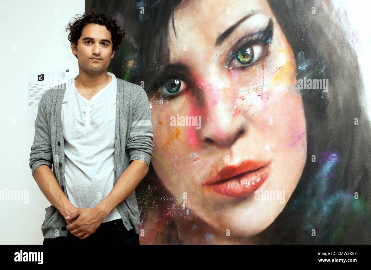 Artist Johan Andersson stands next to his portrait painting of the late ...