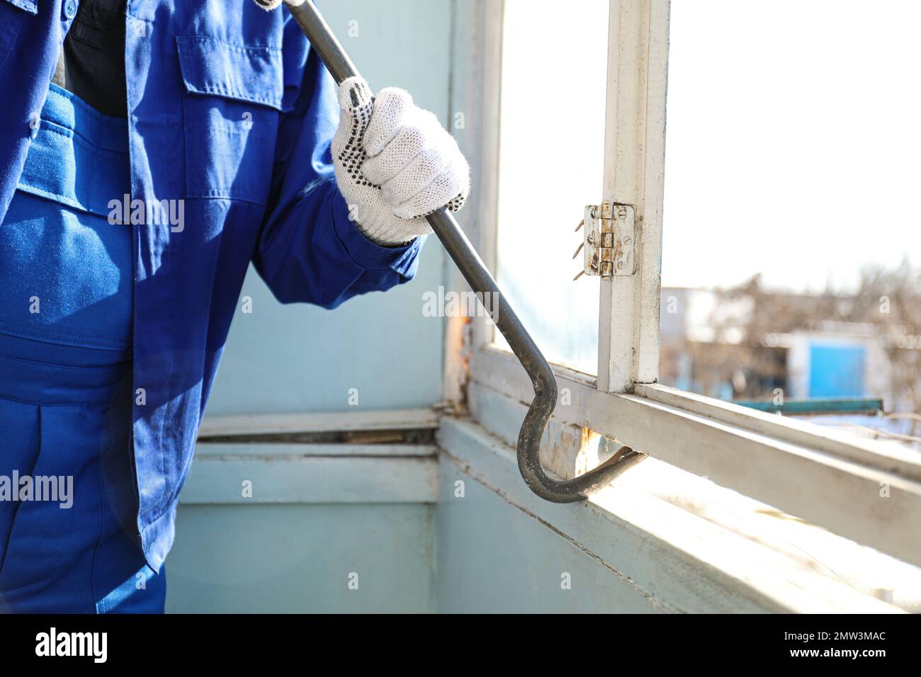 Worker dismantling old window with crowbar indoors, closeup Stock Photo ...