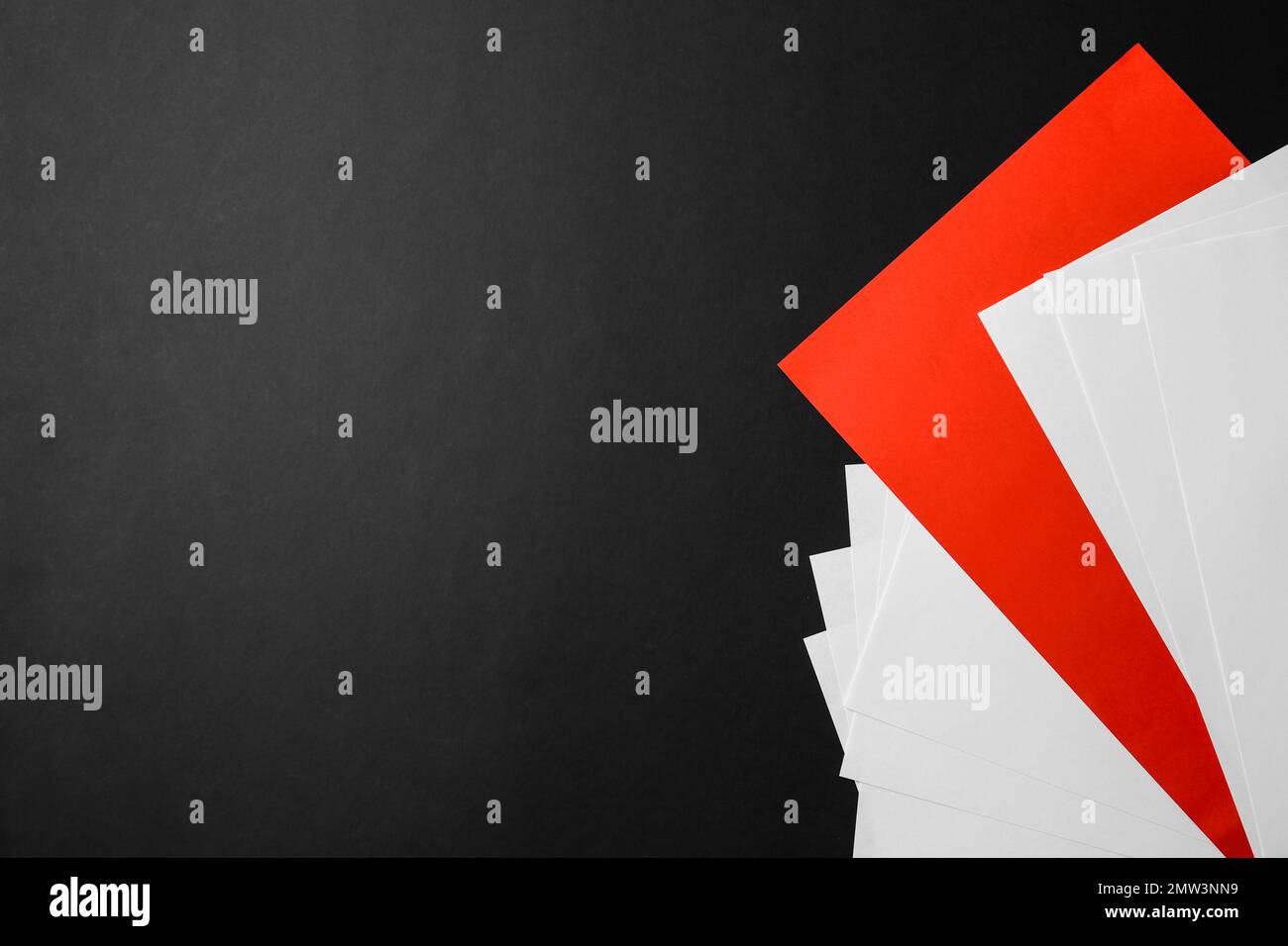 White paper sheets and different one on black background, flat lay ...