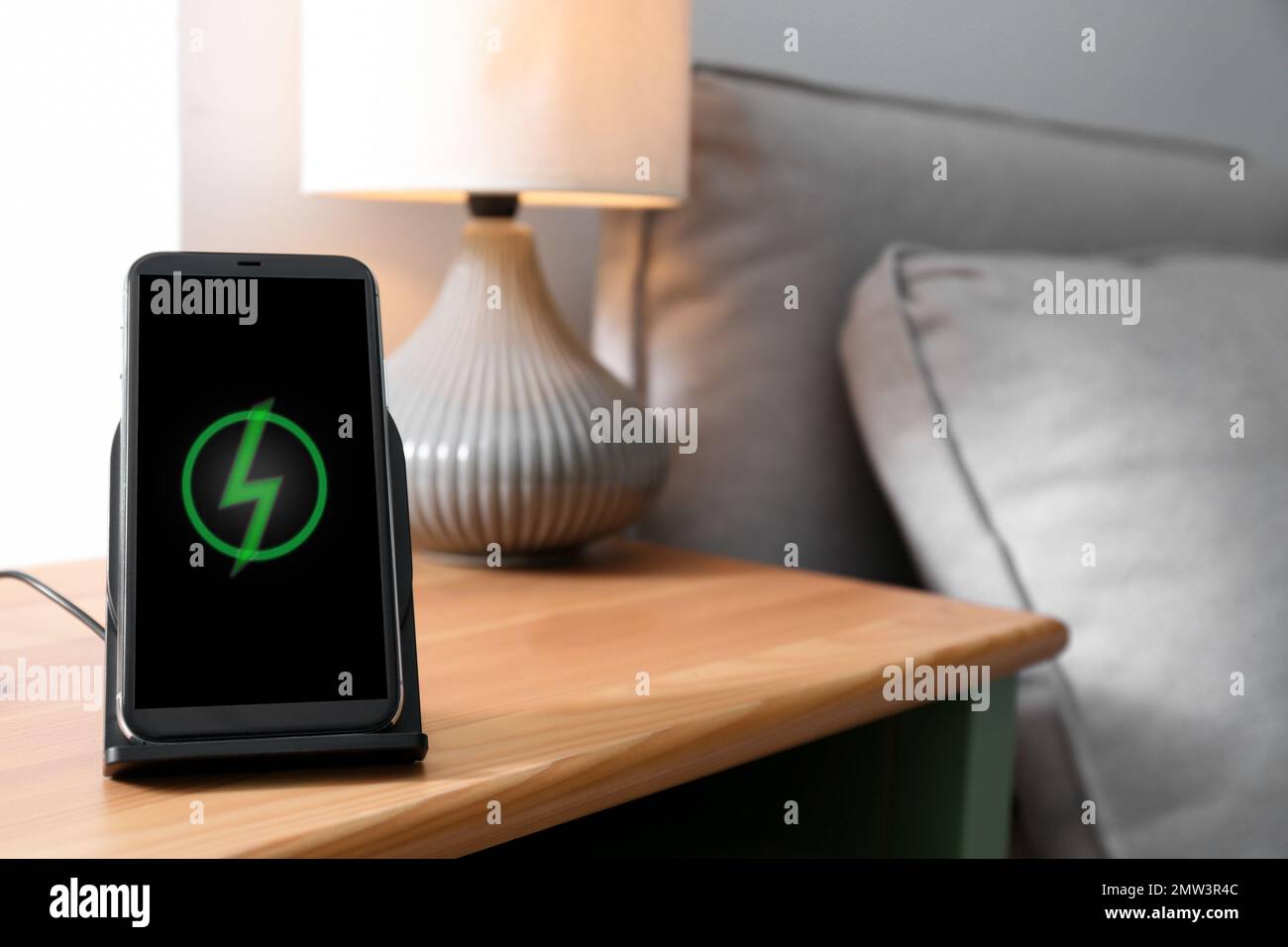 Smartphone charging on wireless pad in room. Space for text Stock Photo ...