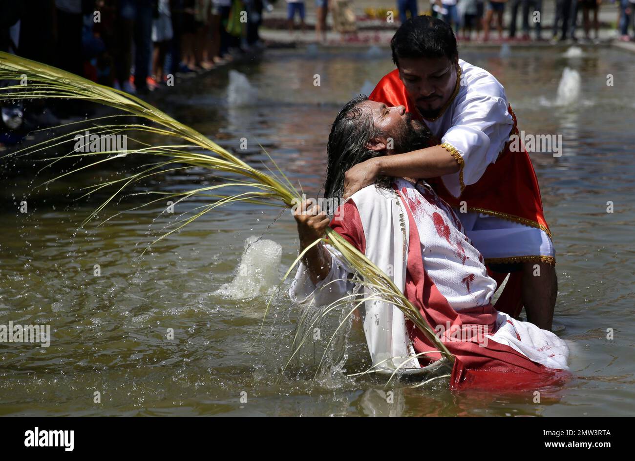 Actors reenact the baptism of Jesus during Holy Week celebrations in ...