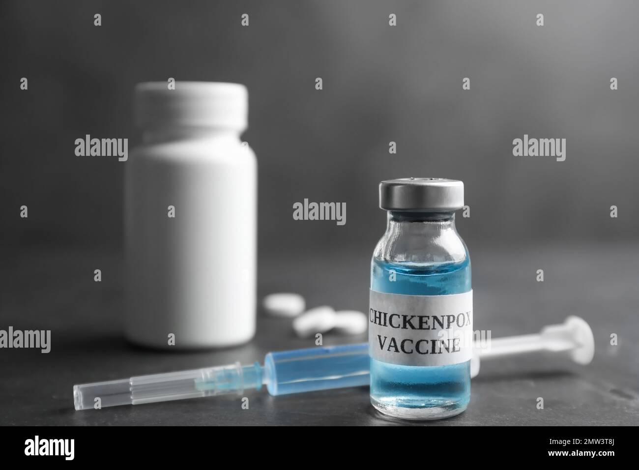 Chickenpox vaccine and syringe on grey background. Varicella virus ...